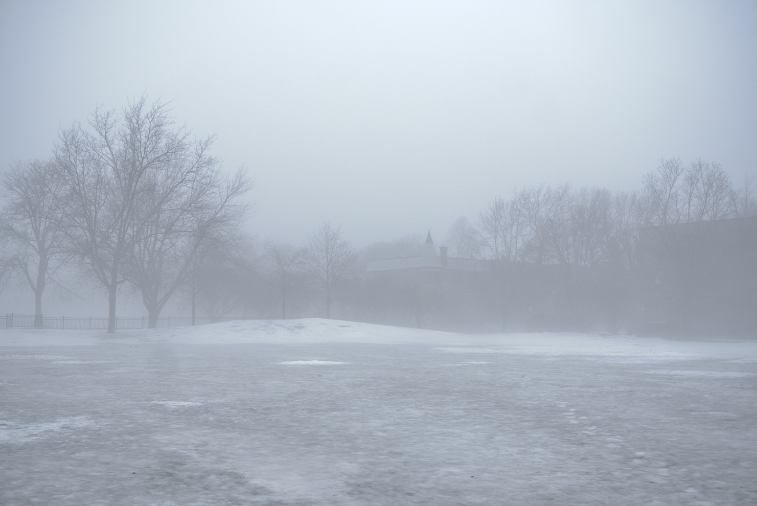 Trees and a pointy roof vaguely visible in the fog